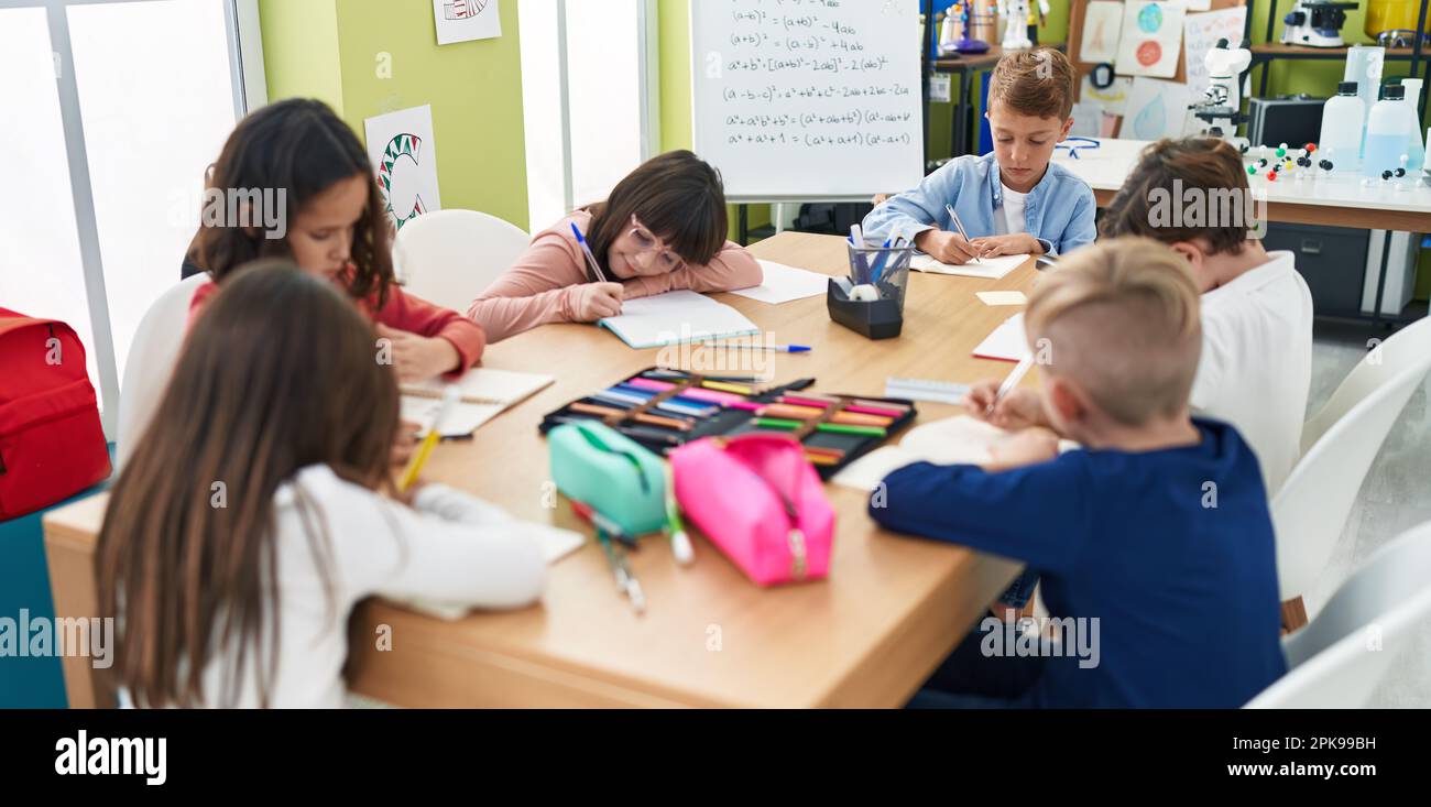 Group of kids students sitting on table studying at classroom Stock ...