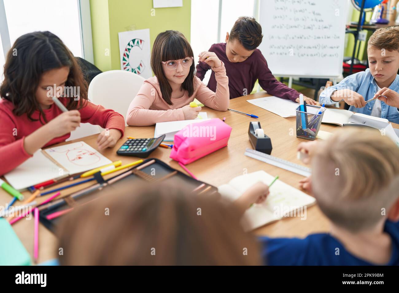 Group of kids students sitting on table studying at classroom Stock ...