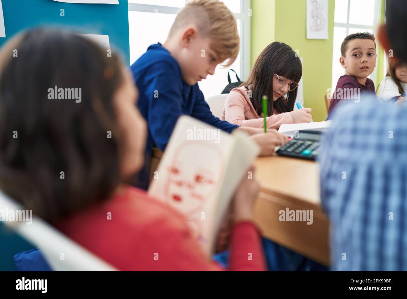 Group of kids students sitting on table studying at classroom Stock ...