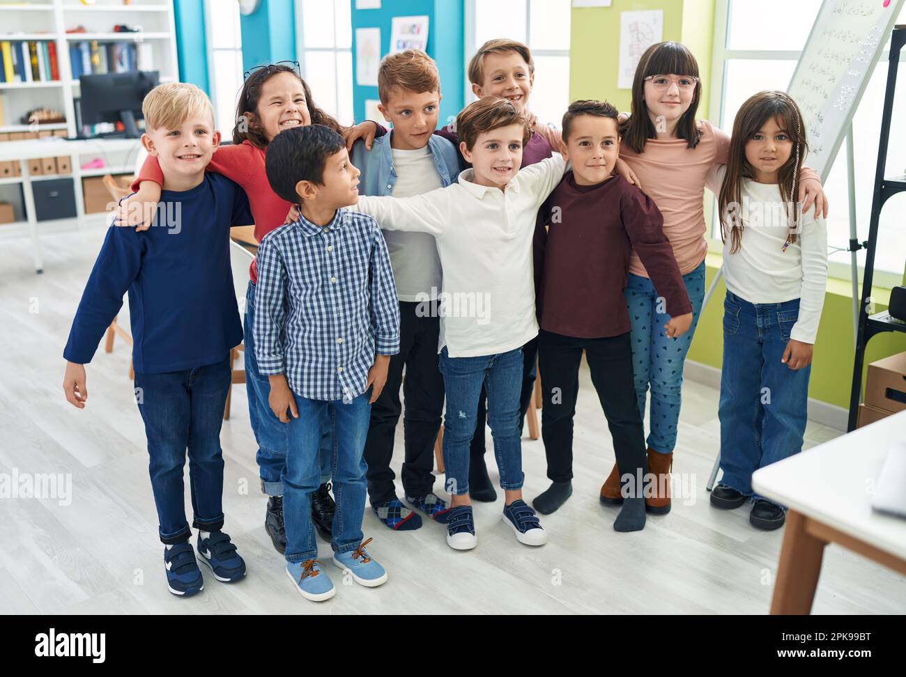 Group of kids students smiling confident hugging each other at ...