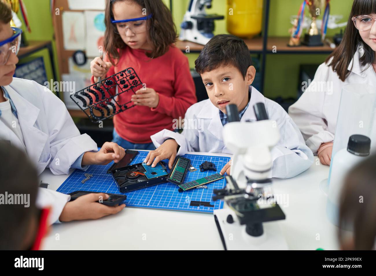 Group of kids students using microscope repairing gadget at laboratory ...