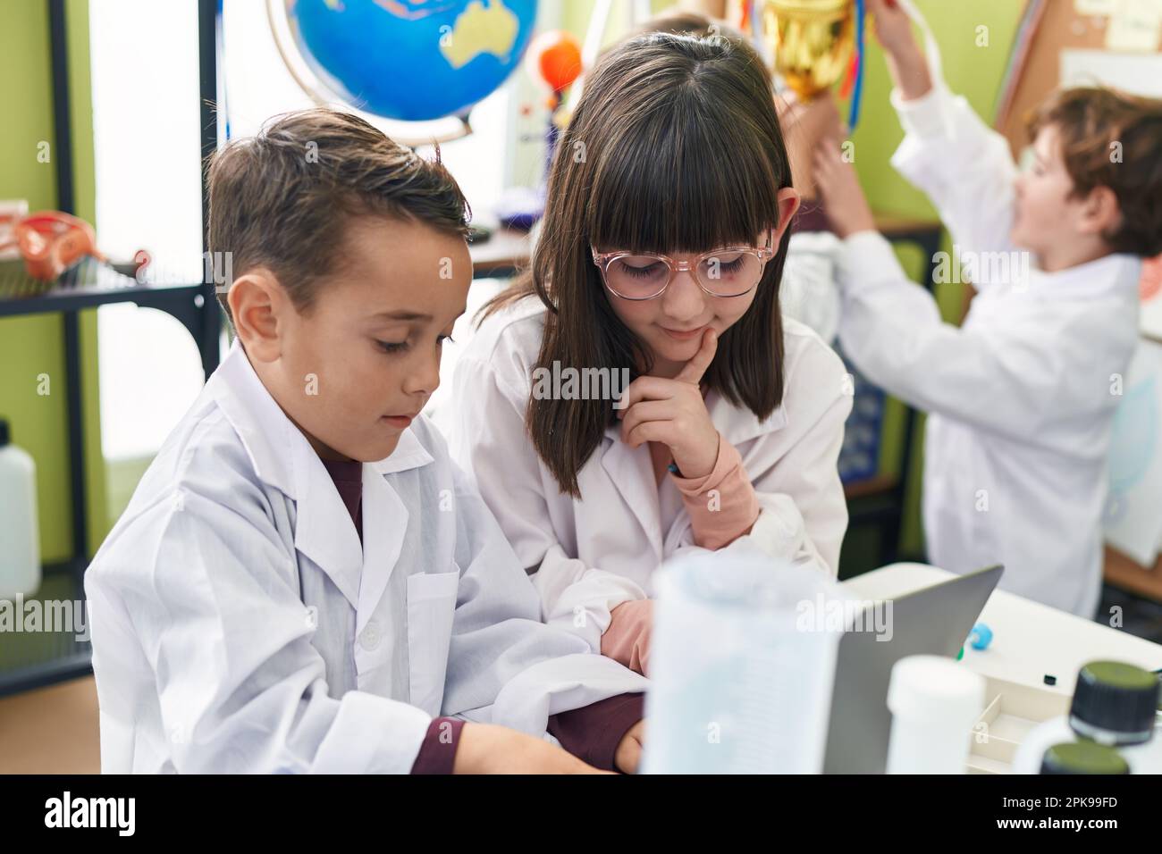 Group of kids scientists students using laptop at laboratory classroom ...