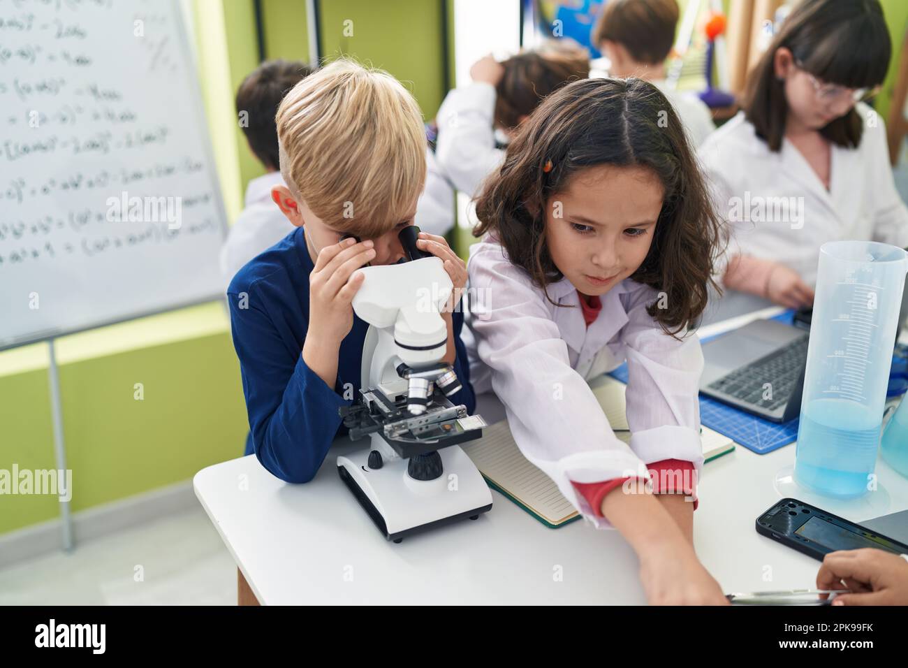 Group of kids students using microscope at laboratory classroom Stock ...