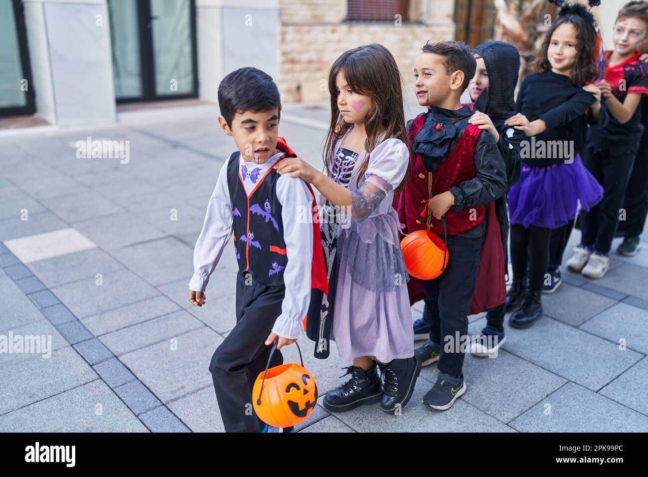 Group of kids wearing halloween costume walking together at street ...
