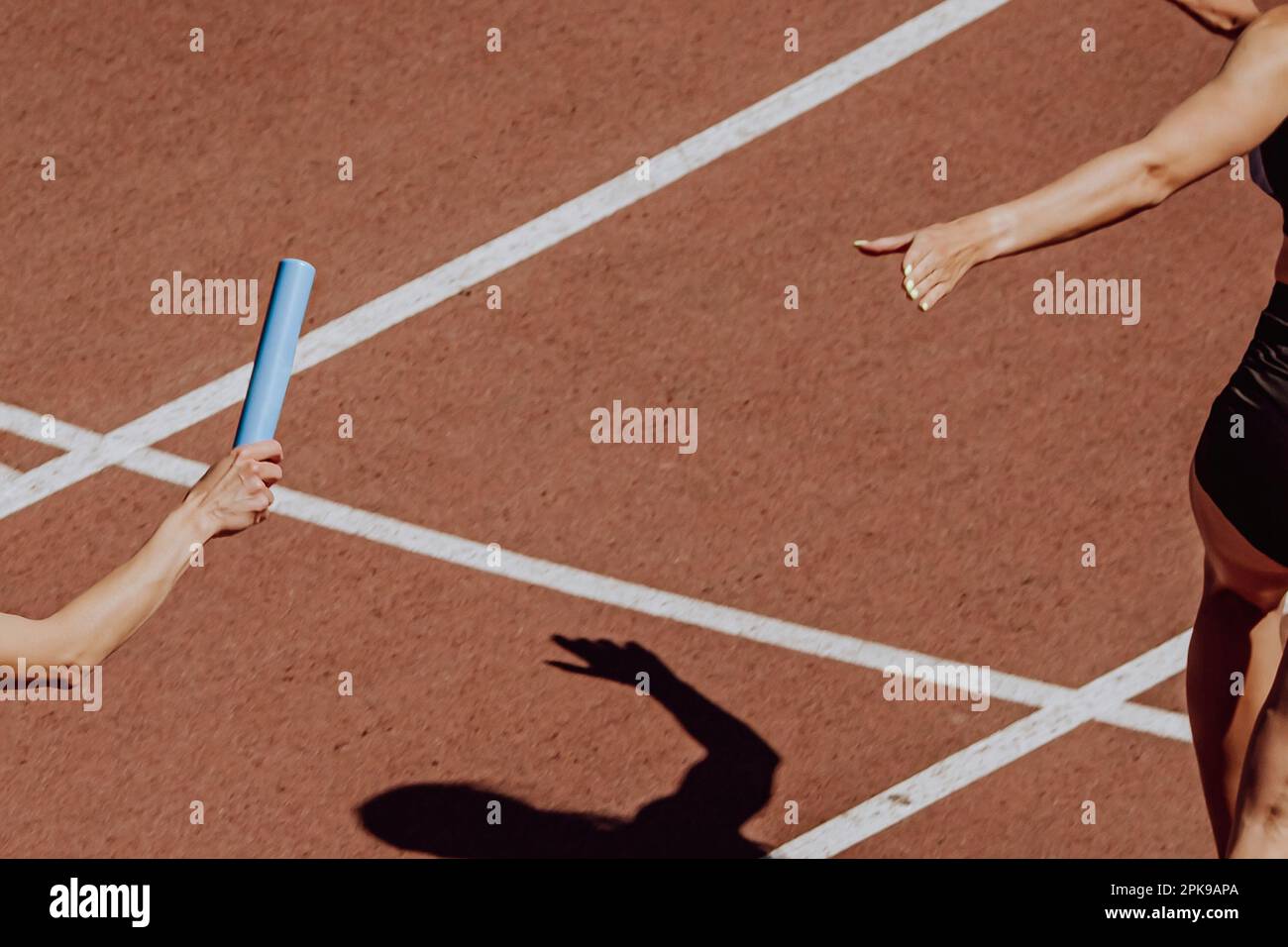 hand women runner passing baton running relay race in summer athletics ...