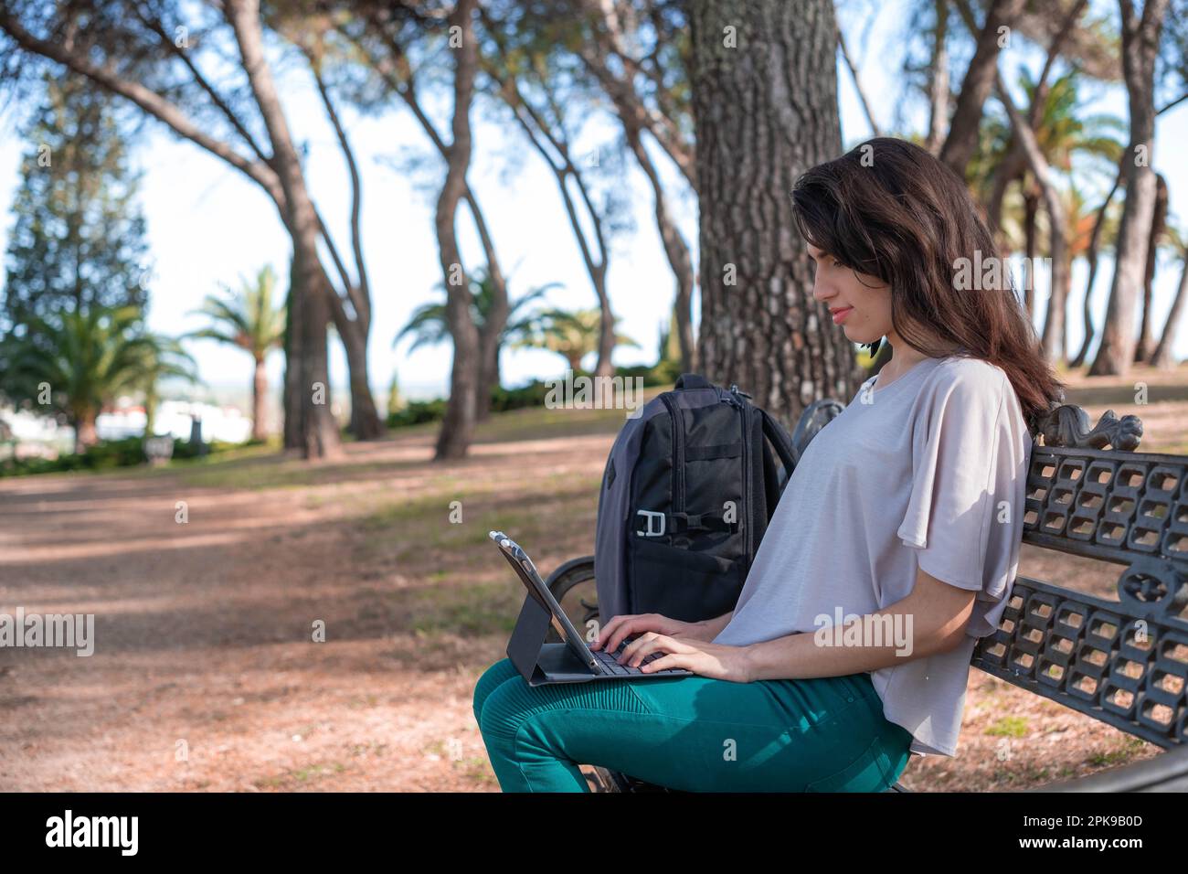 Transgender woman working with a laptop sitting on a bench Stock Photo ...