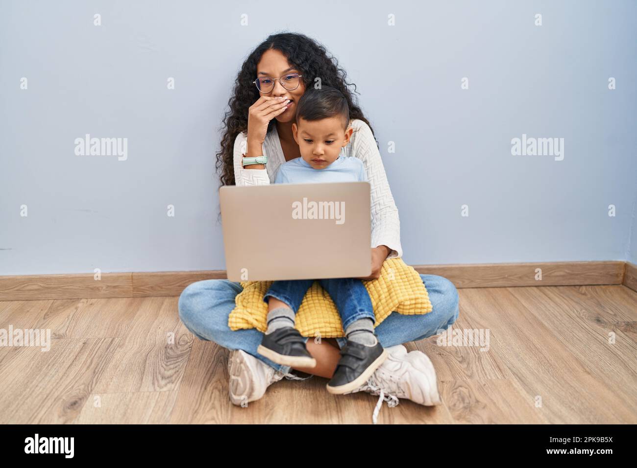 Young hispanic mother and kid using computer laptop sitting on the ...