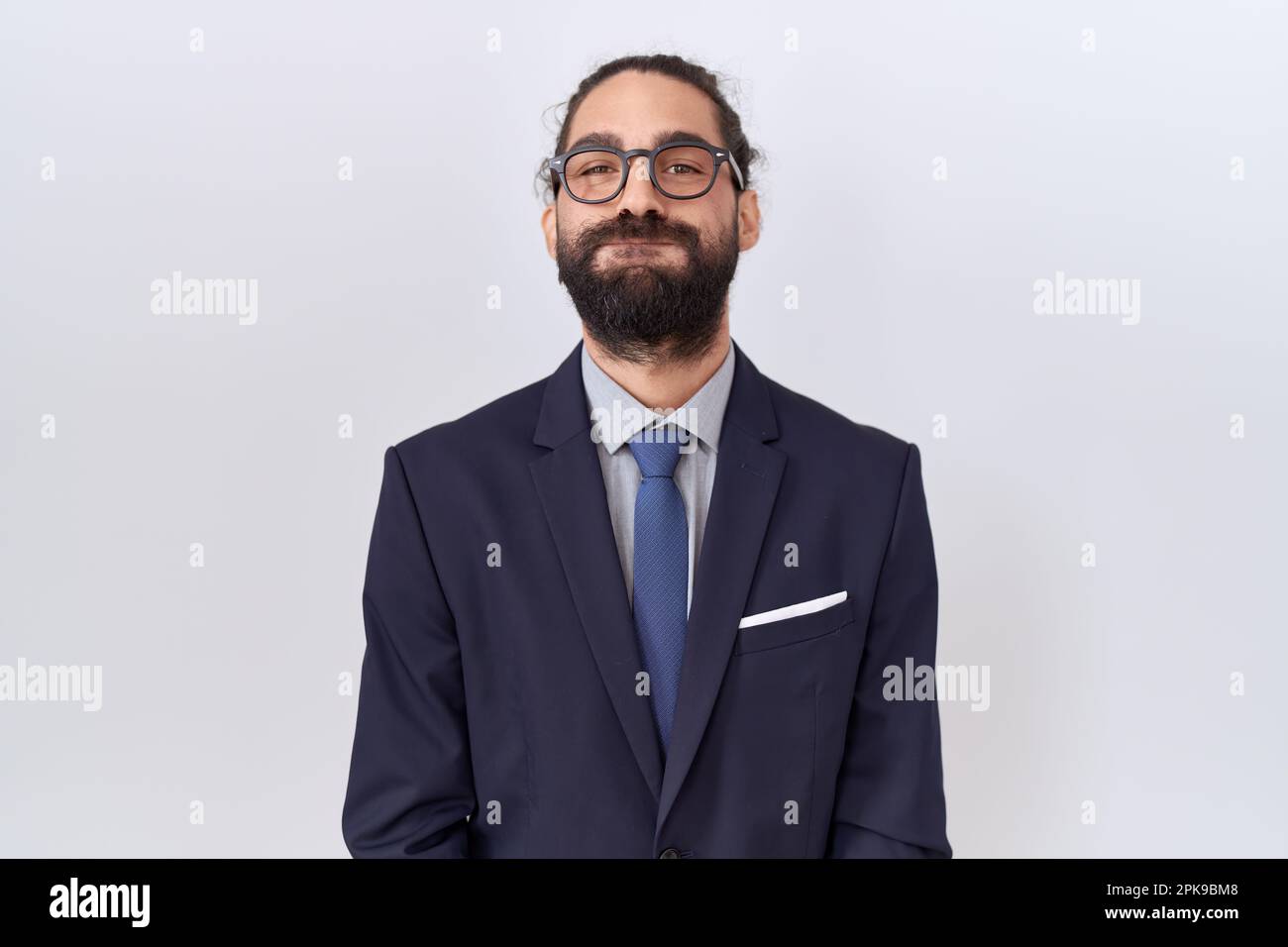 Hispanic man with beard wearing suit and tie puffing cheeks with funny ...
