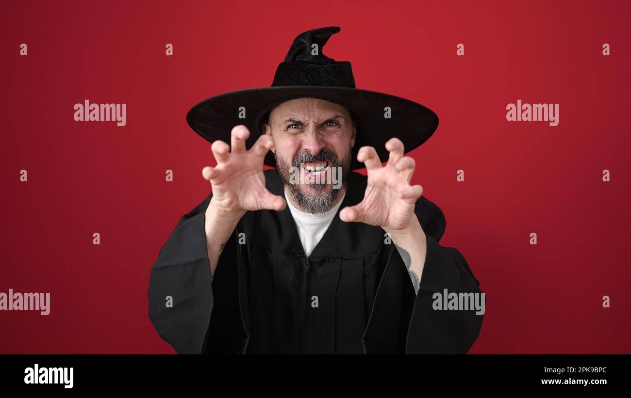 Young bald man wearing wizard costume doing fear gesture over isolated ...