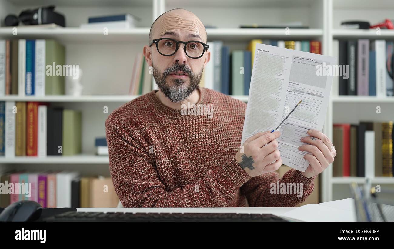 Young bald man student showing document speaking at university ...