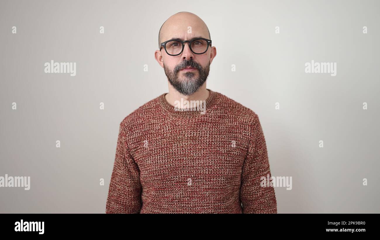 Young bald man standing with serious expression over isolated white ...