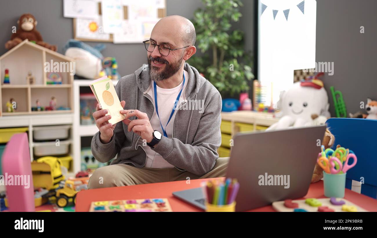 Young bald man preschool teacher teaching vocabulary lesson on video ...