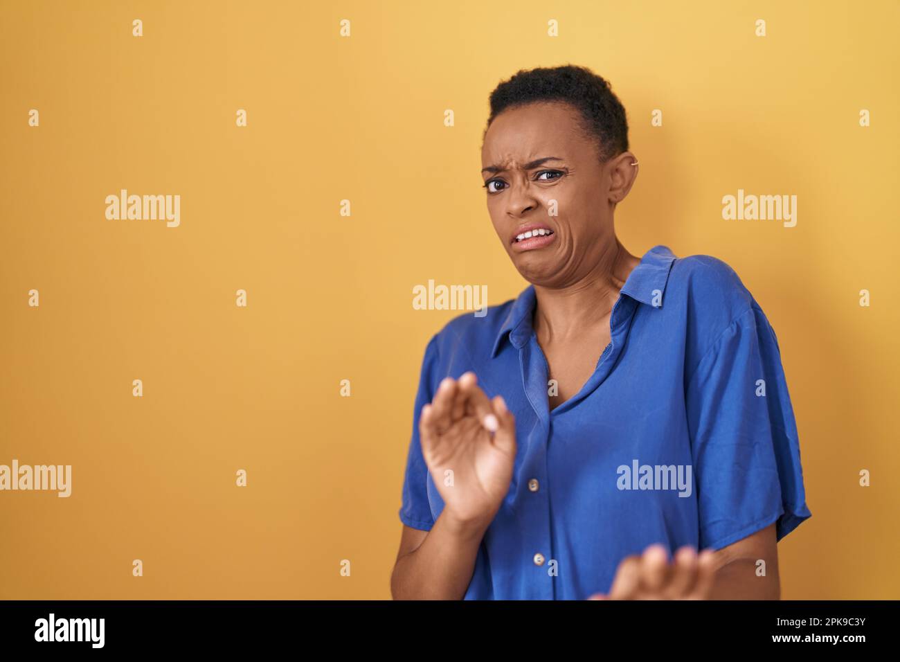 African american woman standing over yellow background disgusted ...