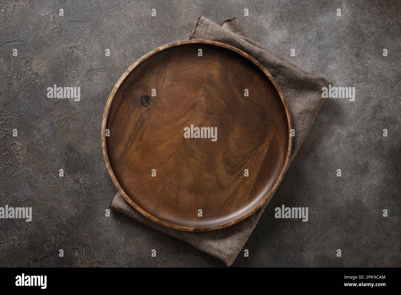 Kitchen wooden tray with linen towel on brown table top. Top view ...