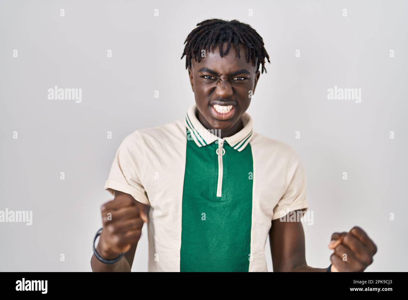 African man with dreadlocks standing over isolated background angry and ...