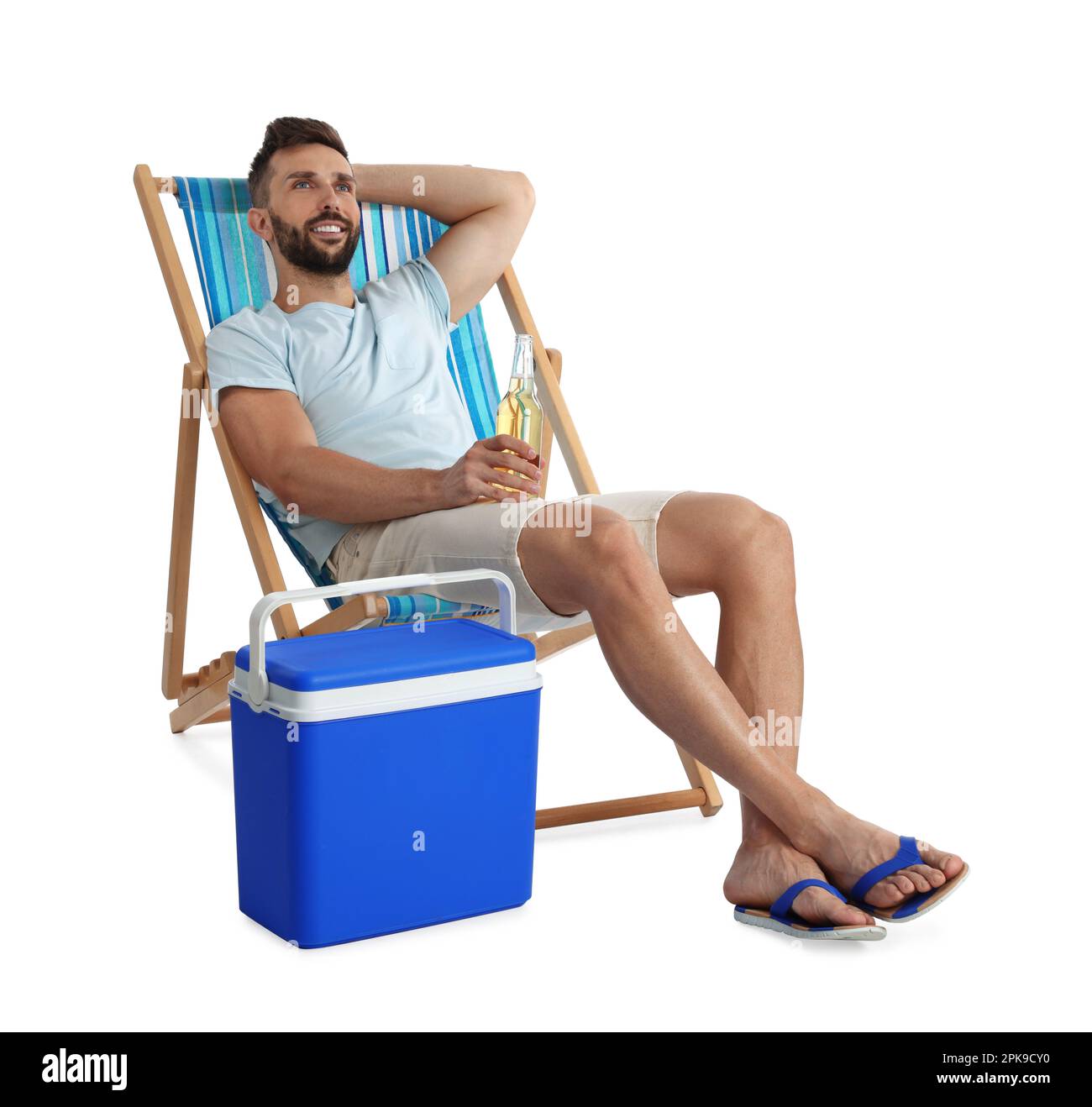 Happy man with bottle of beer resting in deck chair near cool box on ...