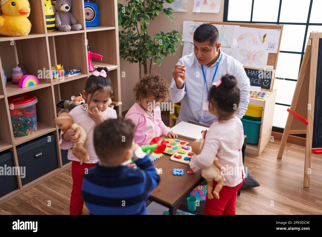 Hispanic man and group of kids having lesson at kindergarten Stock ...