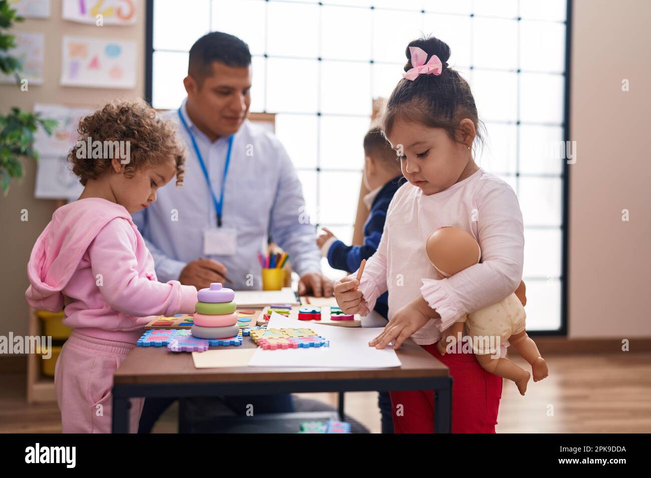 Hispanic man and group of kids having lesson at kindergarten Stock ...