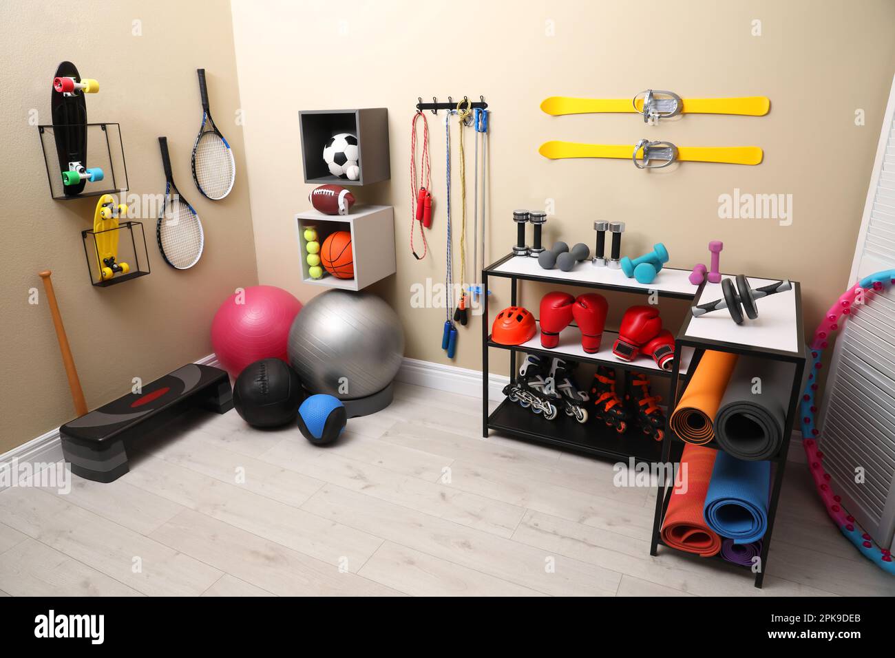 Many different sports equipment in room with beige walls Stock Photo ...