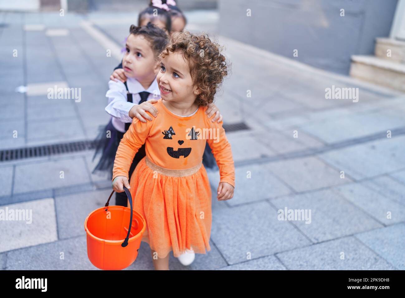 Group of kids wearing halloween costume walking together at street ...