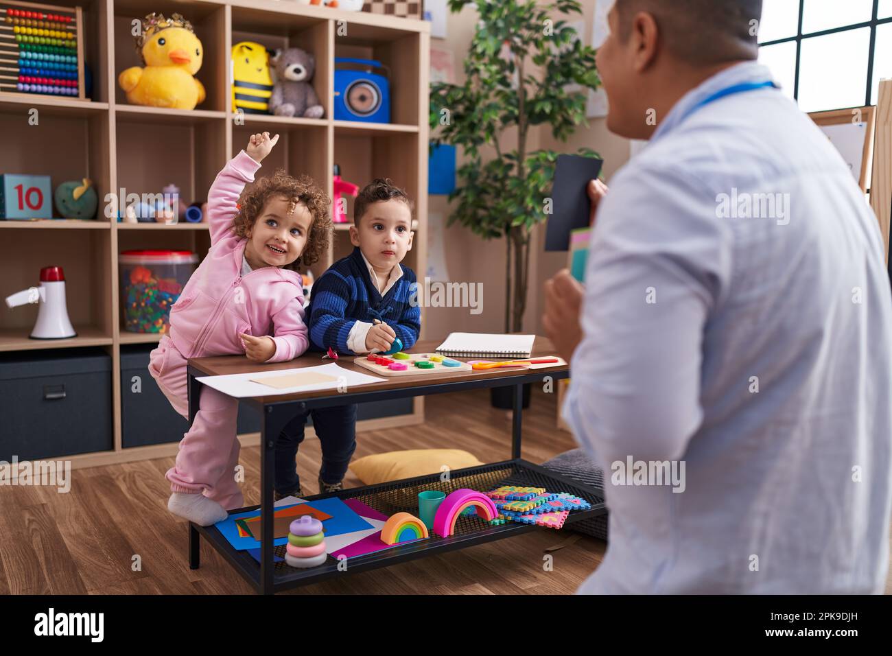 Hispanic man with boy and girl playing with vocabulary game standing at ...