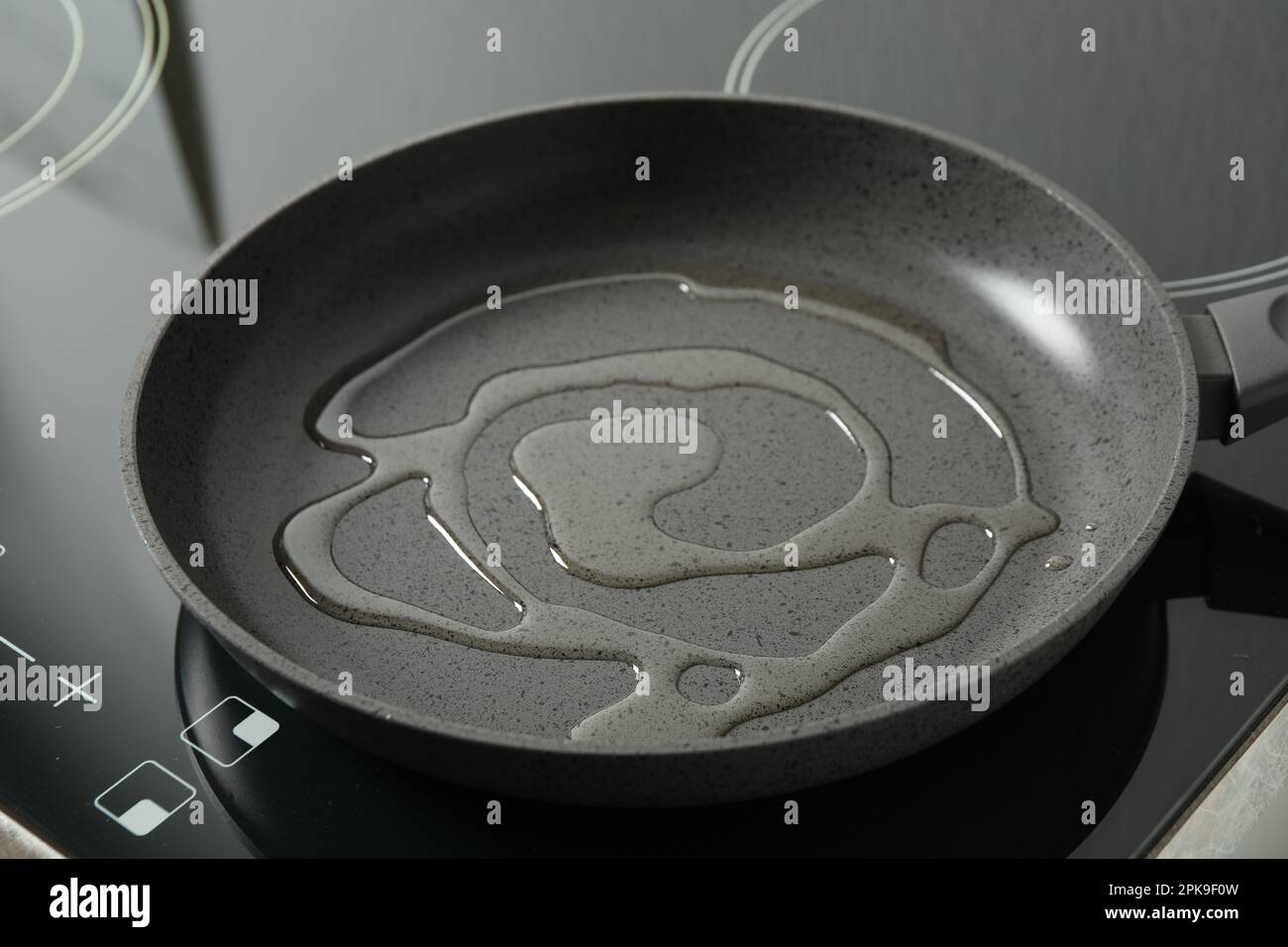 Frying pan with cooking oil on induction stove Stock Photo - Alamy