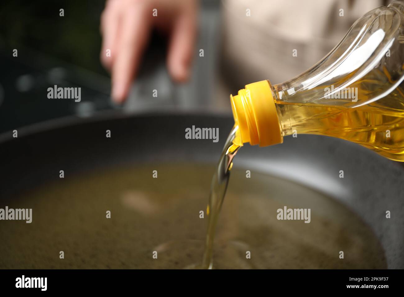 Woman pouring cooking oil from bottle into frying pan, closeup Stock ...