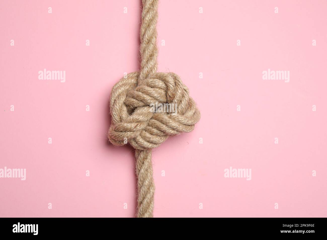 Linen rope with knot on pink background, top view. Unity concept Stock ...