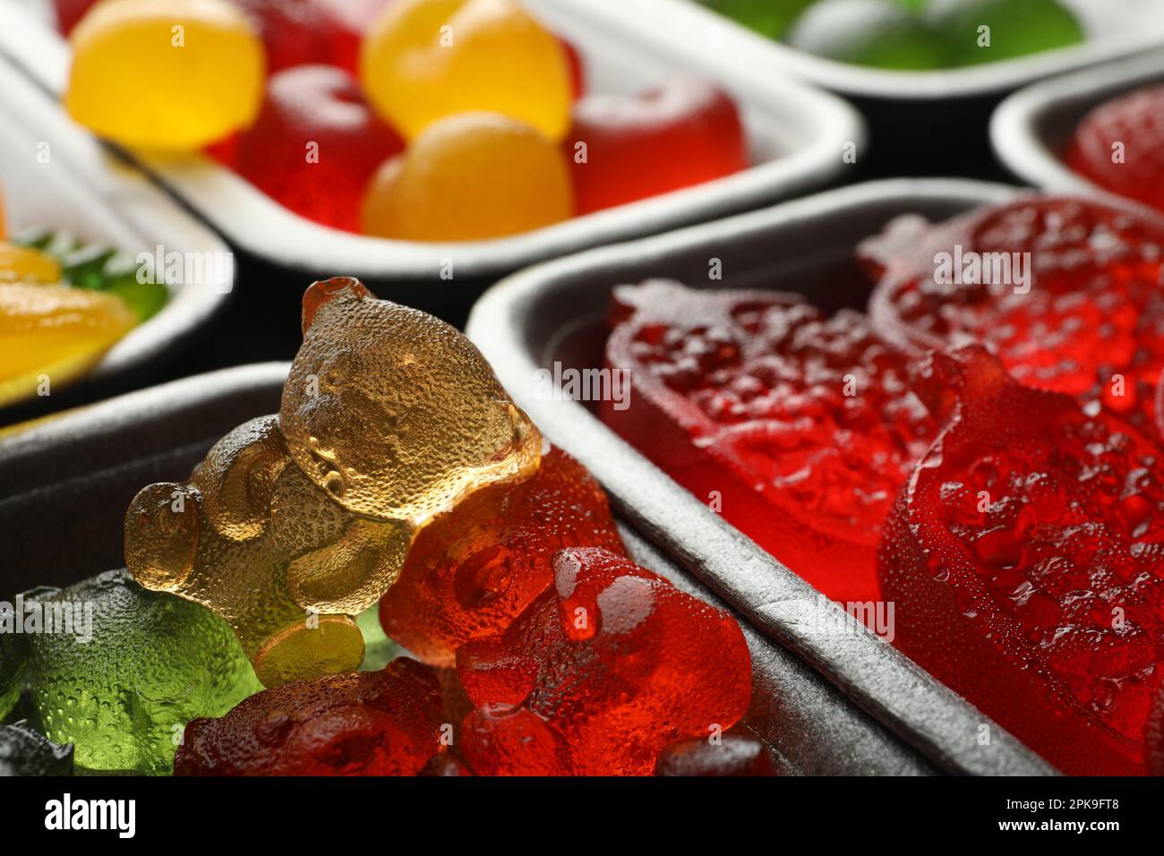 Different delicious gummy candies in containers, closeup Stock Photo ...