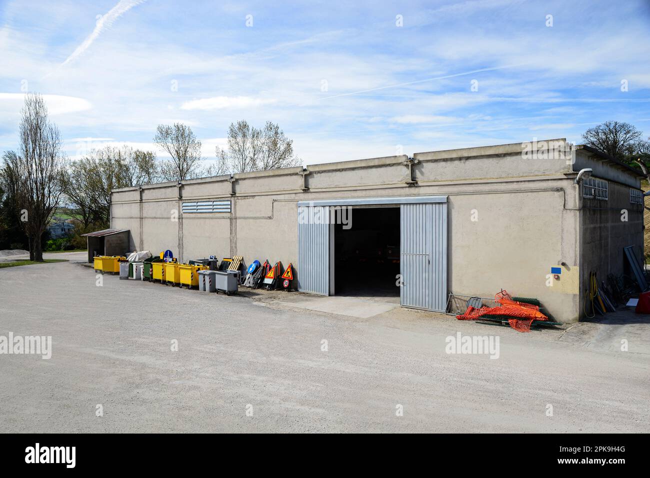 Many traffic signs and containers near garage Stock Photo - Alamy