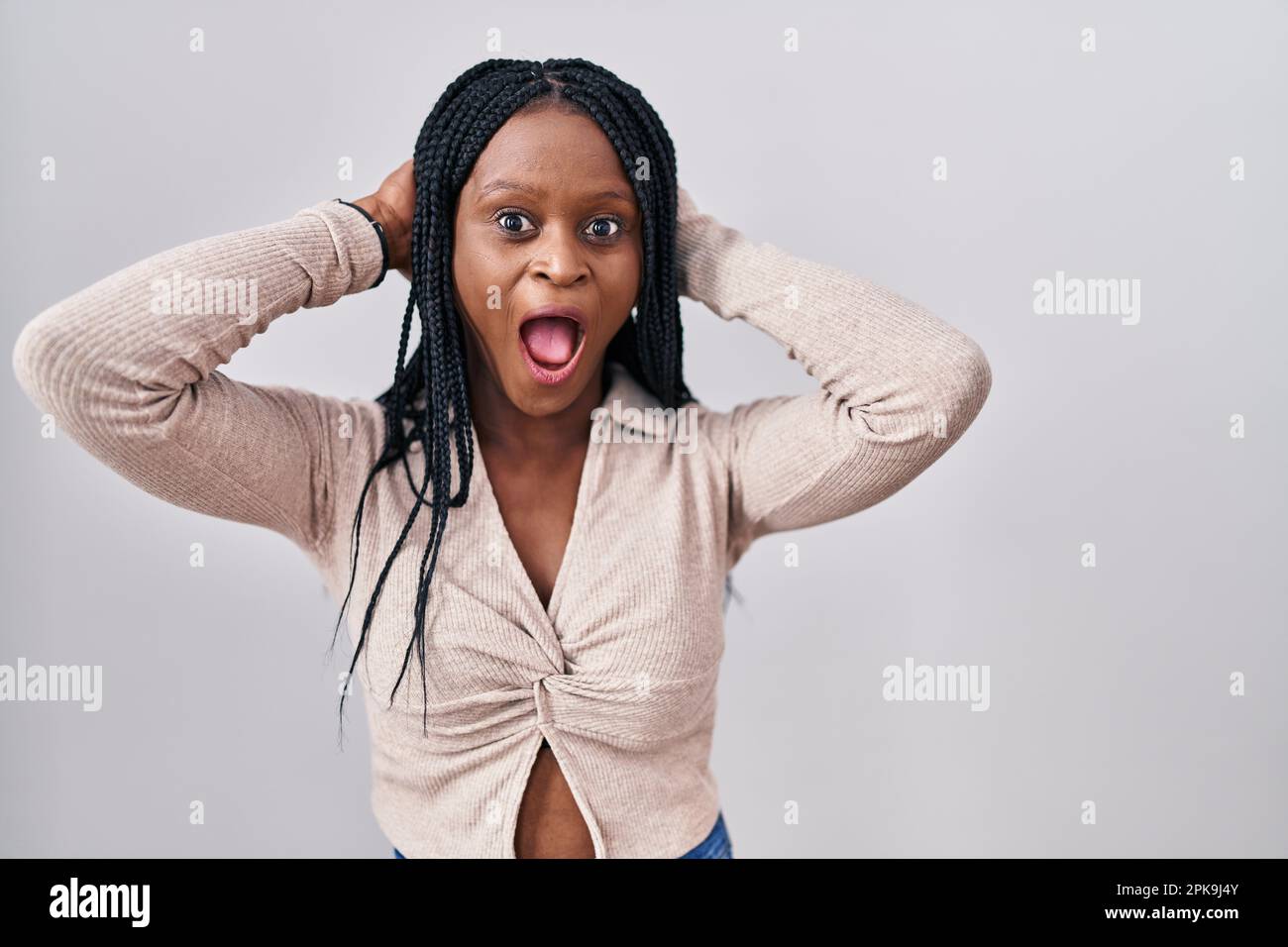 African woman with braids standing over white background crazy and ...