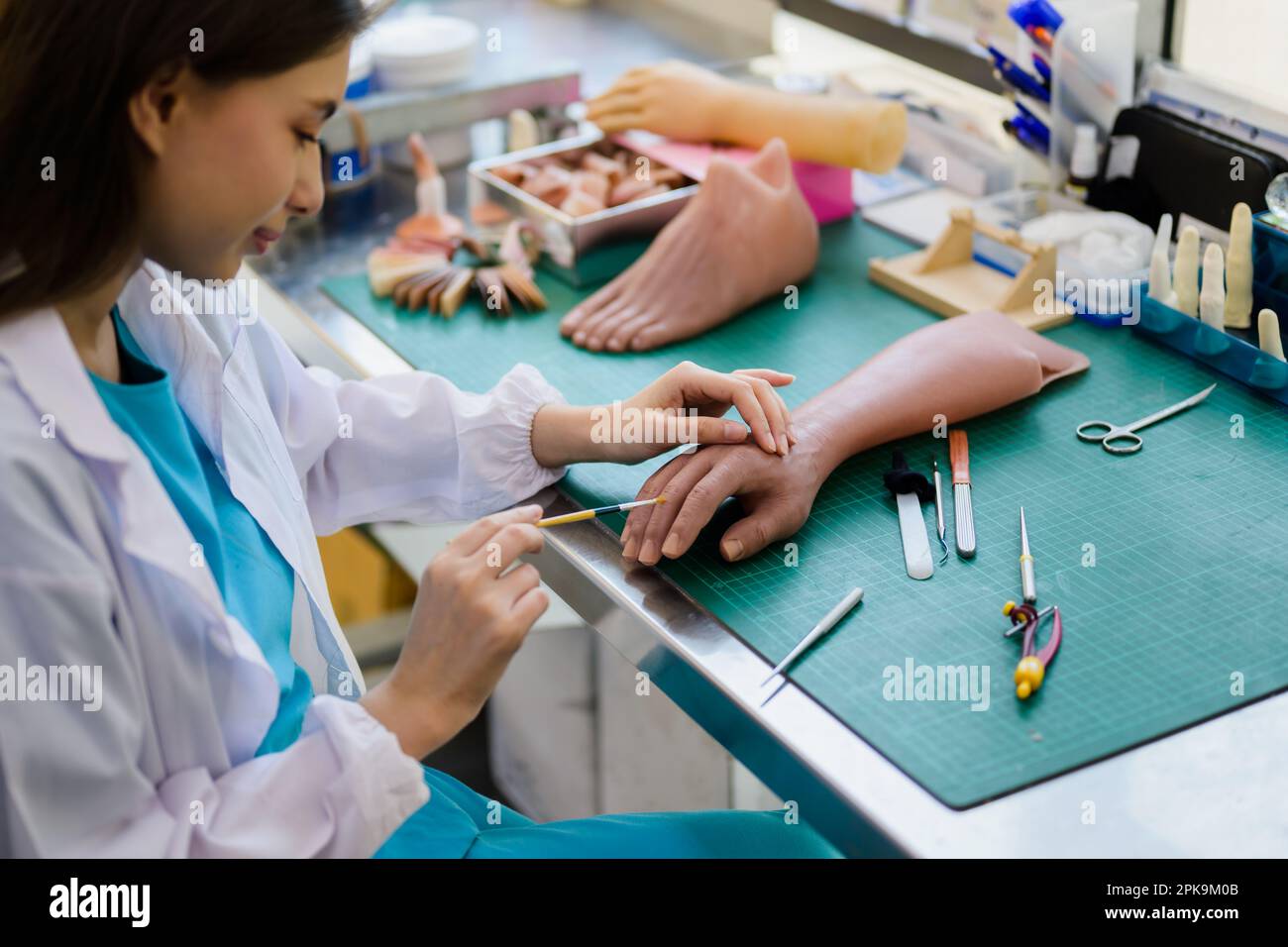Technician making and checking prosthetic limb at prosthetic workshop ...