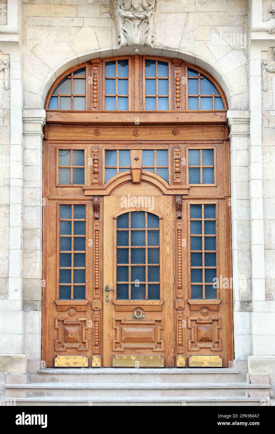 Entrance of house with beautiful arched wooden door, elegant molding ...