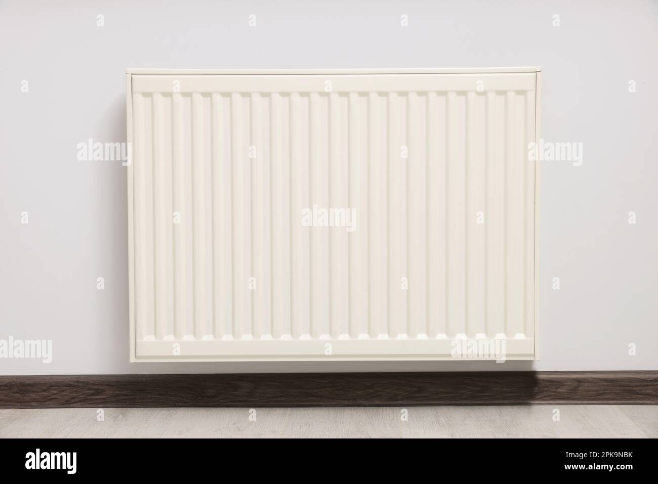 Modern radiator on white wall in room. Central heating system Stock ...