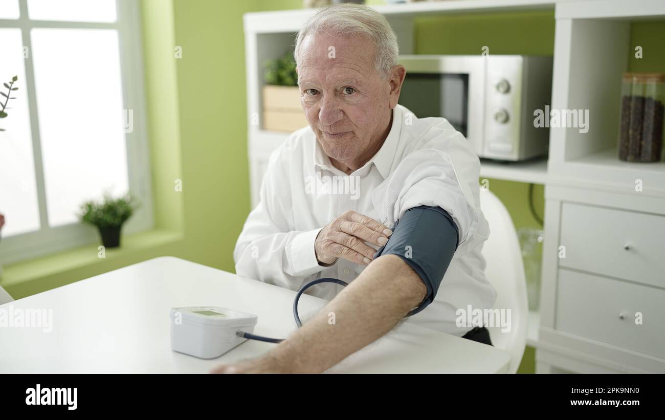 senior measuring pulse using tensiometer at home Stock Photo - Alamy