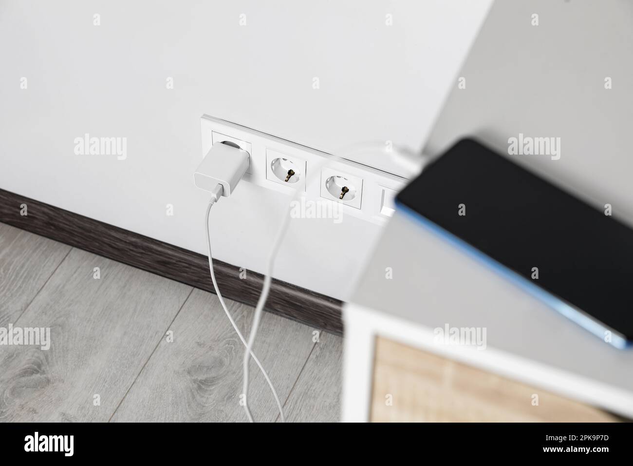 Modern smartphone charging from electric socket indoors Stock Photo - Alamy
