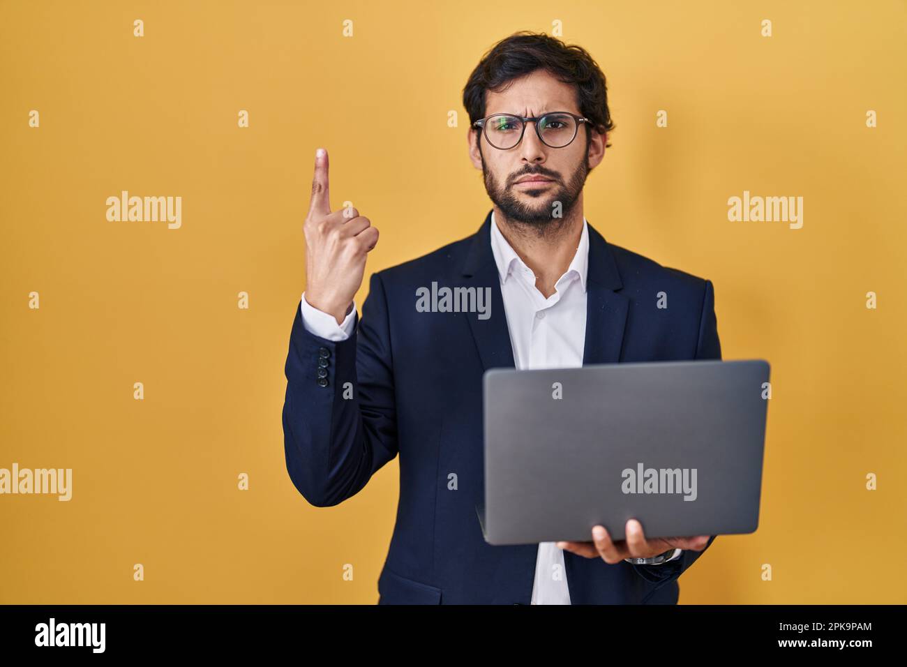 Handsome latin man working using computer laptop pointing up looking ...