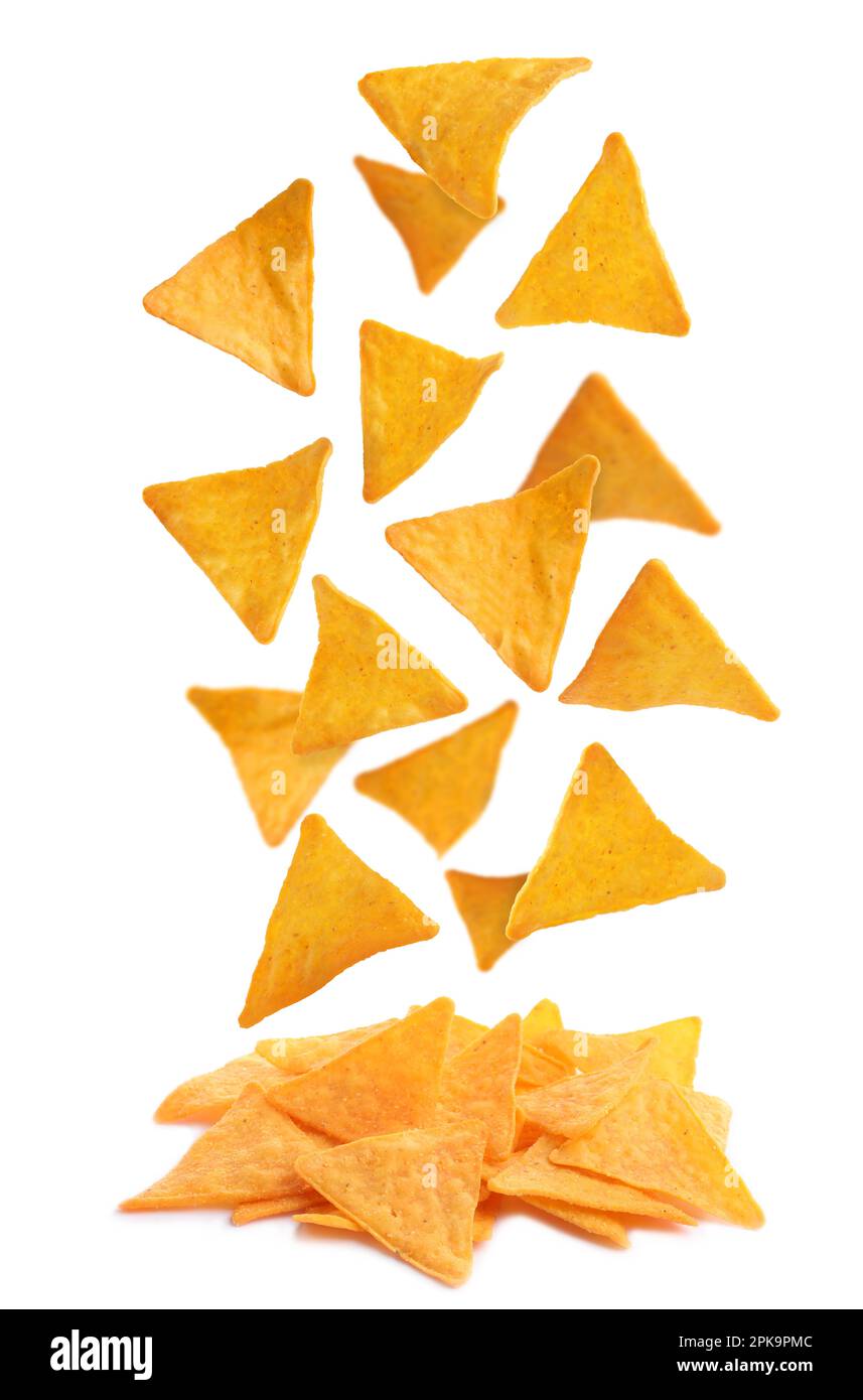 Tasty tortilla chips (nachos) falling into pile on white background ...