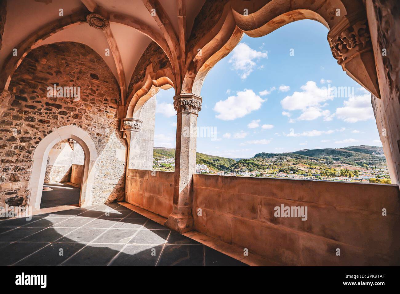A majestic stone archway frames an expansive interior filled with tall ...