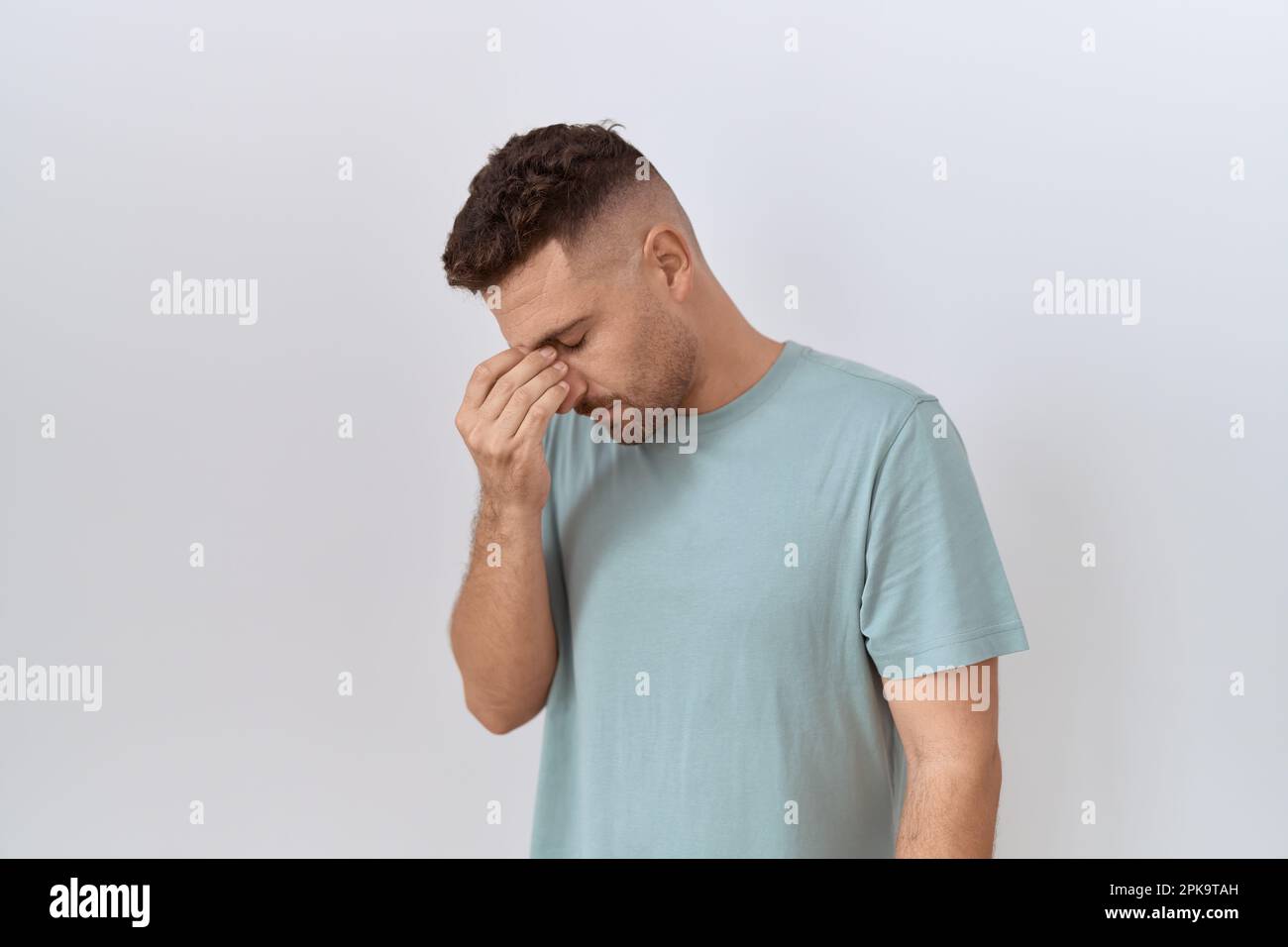 Hispanic man with beard standing over white background tired rubbing ...