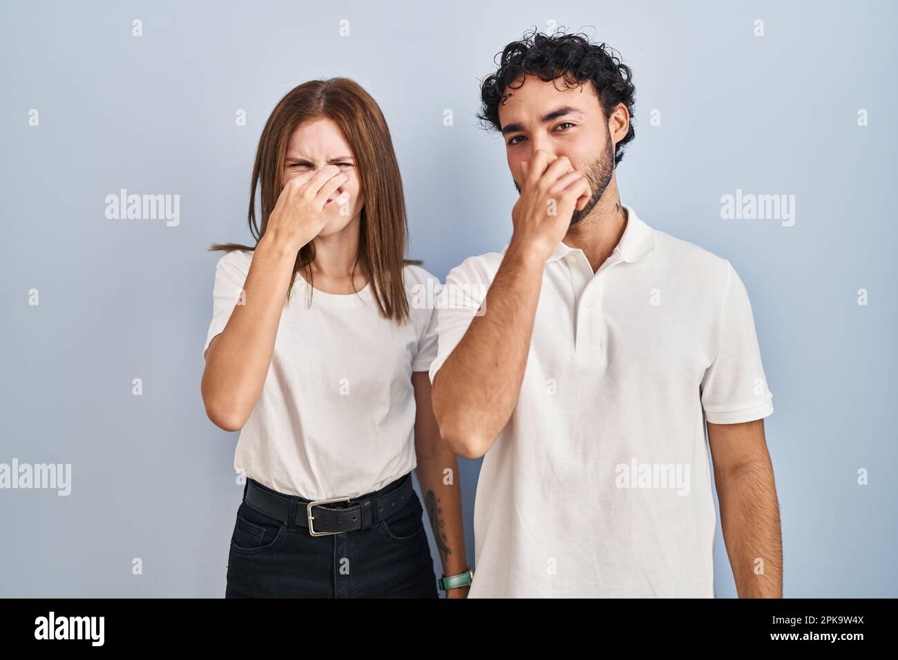 Young couple wearing casual clothes standing together smelling ...