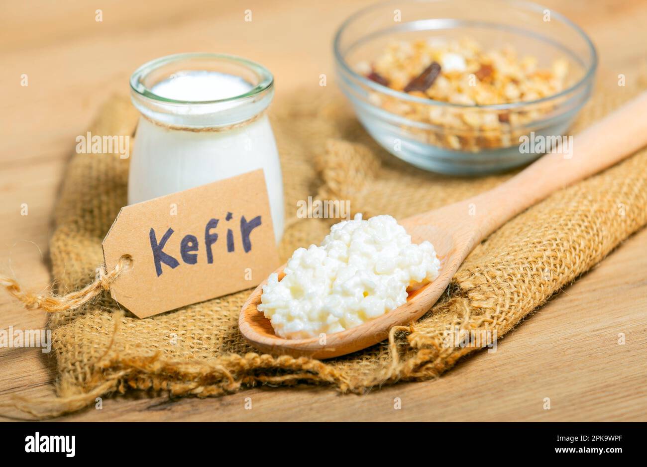 Kefir grains in wooden spoon in front of cups of Kefir Yogurt Parfaits ...