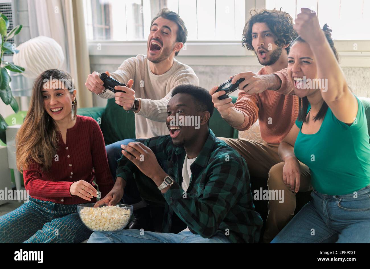 Group of friends play video games together at home, having fun Stock ...