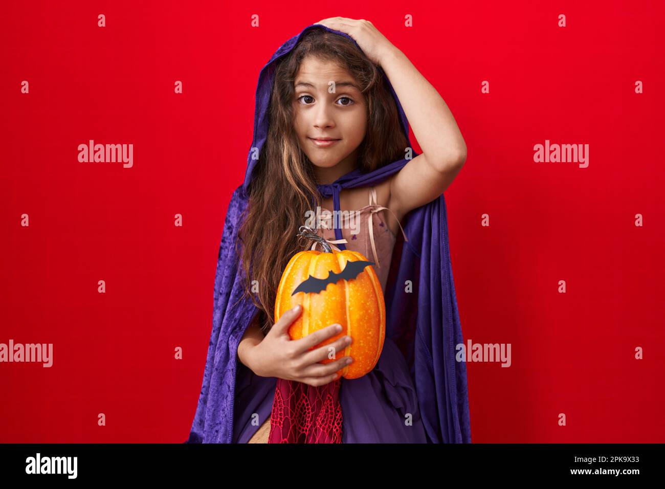 Little hispanic girl wearing witch halloween costume stressed and ...