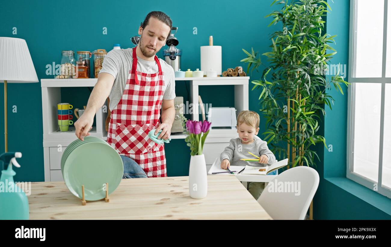 Father and son cleaning plates taking care child at dinning room Stock ...