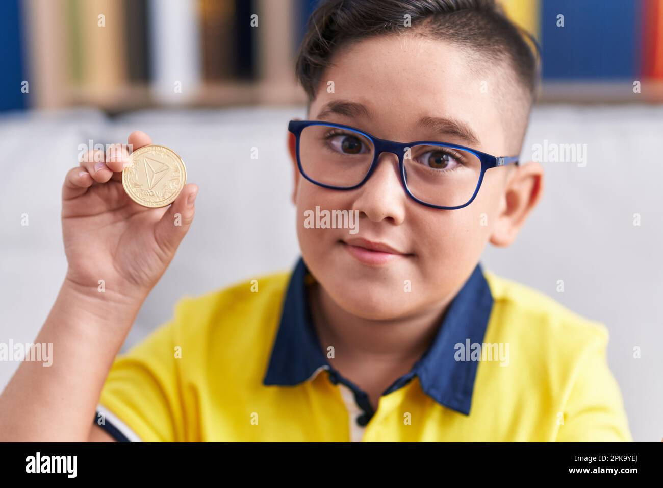 Young hispanic kid holding tron cryptocurrency coin celebrating ...