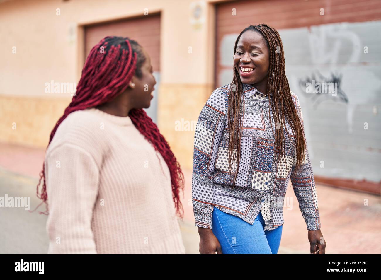 African american women friends standing together speaking at street ...