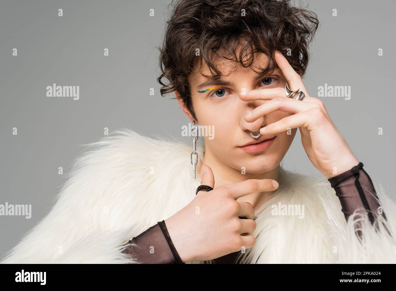 brunette pansexual person in white faux fur jacket and silver ...
