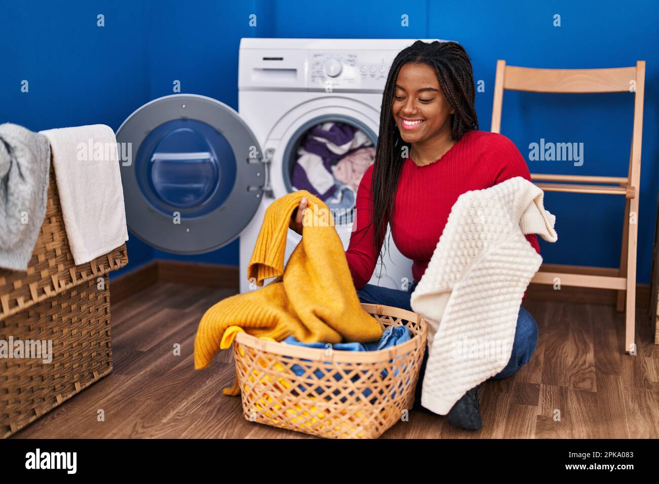 African american woman smiling confident washing clothes at laundry ...