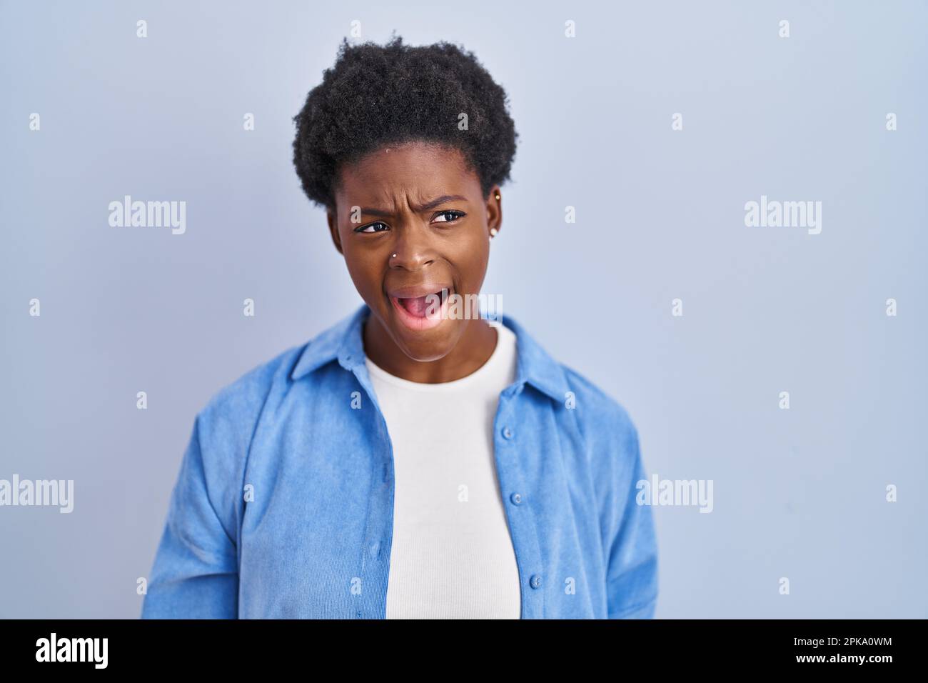 African american woman standing over blue background angry and mad ...